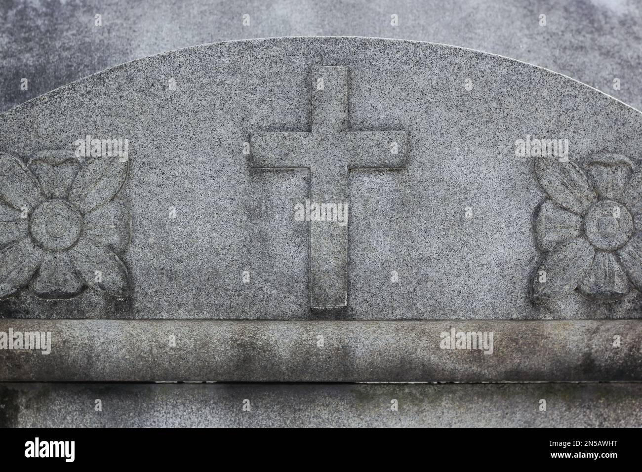 Simple vintage Christian cross standing high on a tombstone in the ...