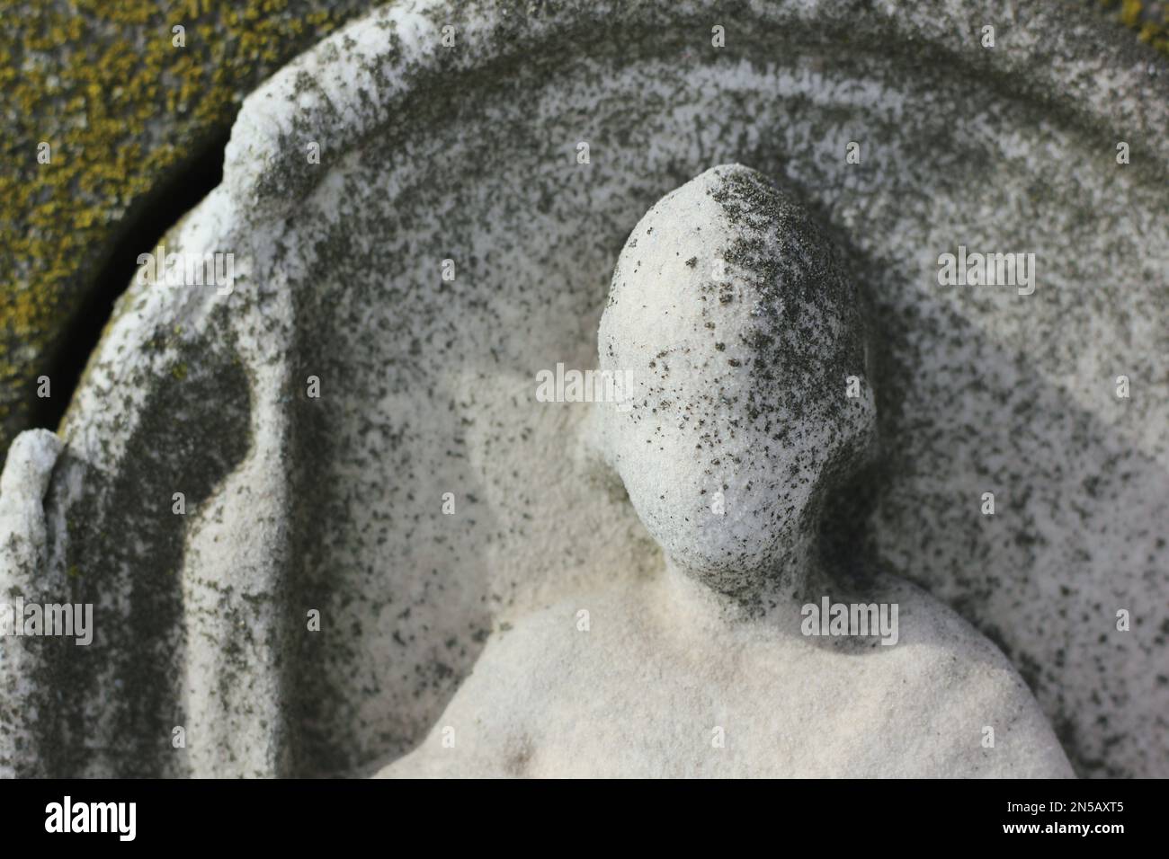 A worn and weathered natural stone statue of Saint Michael the ...