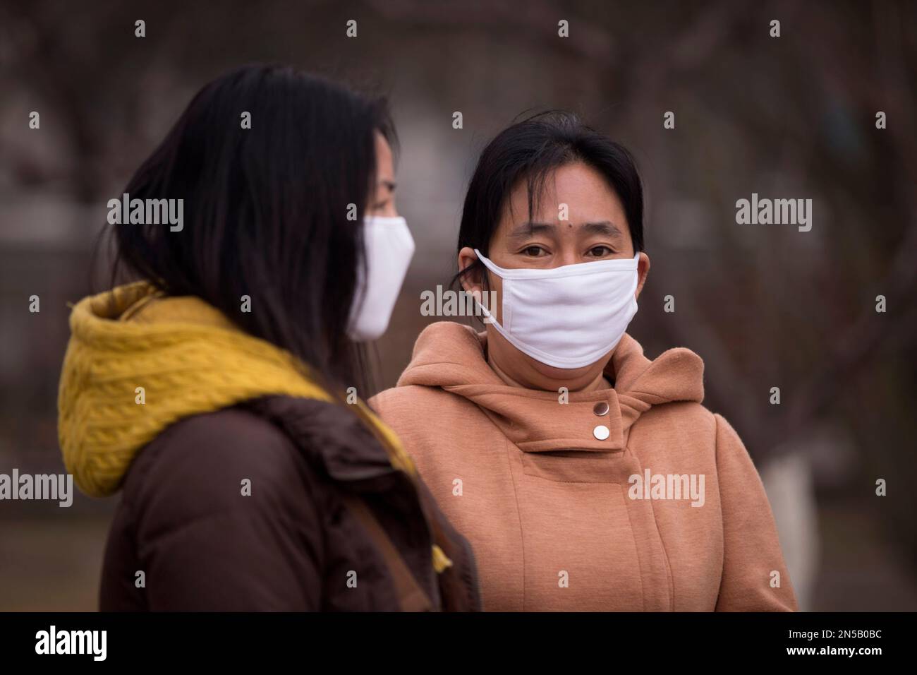 Chinese women wear masks as the capital city is shrouded by a haze of ...