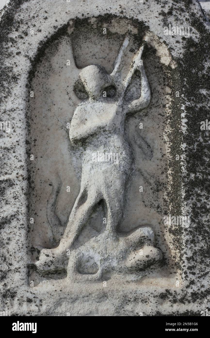 A worn and weathered natural stone statue of Saint Michael the ...