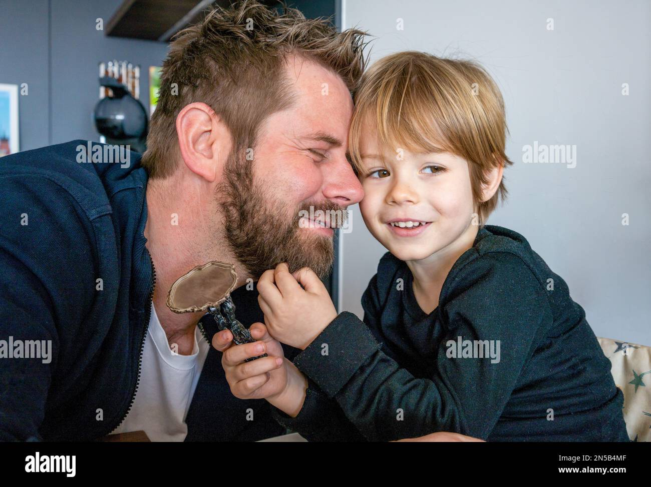 Close-up portrait of happy young father hugging and kissing his sweet ...