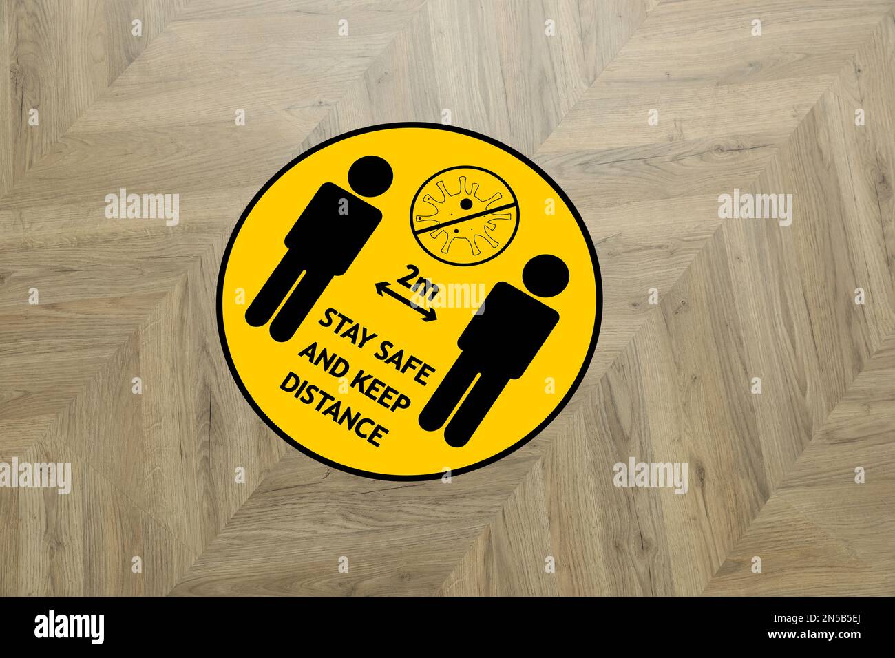 Sign STAY SAFE AND KEEP DISTANCE on floor indoors, above view ...