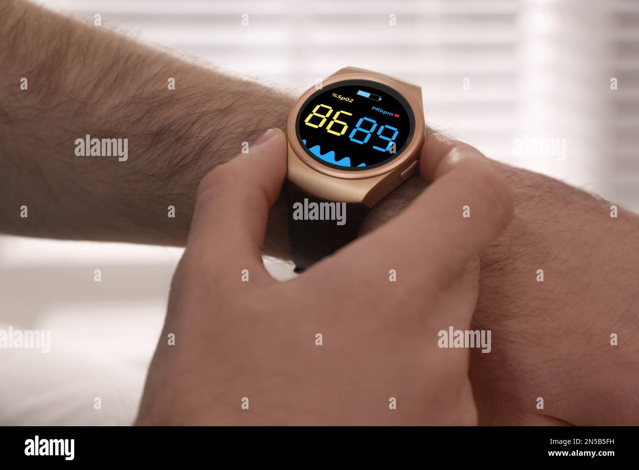 Man measuring oxygen level with smartwatch indoors, closeup Stock Photo ...