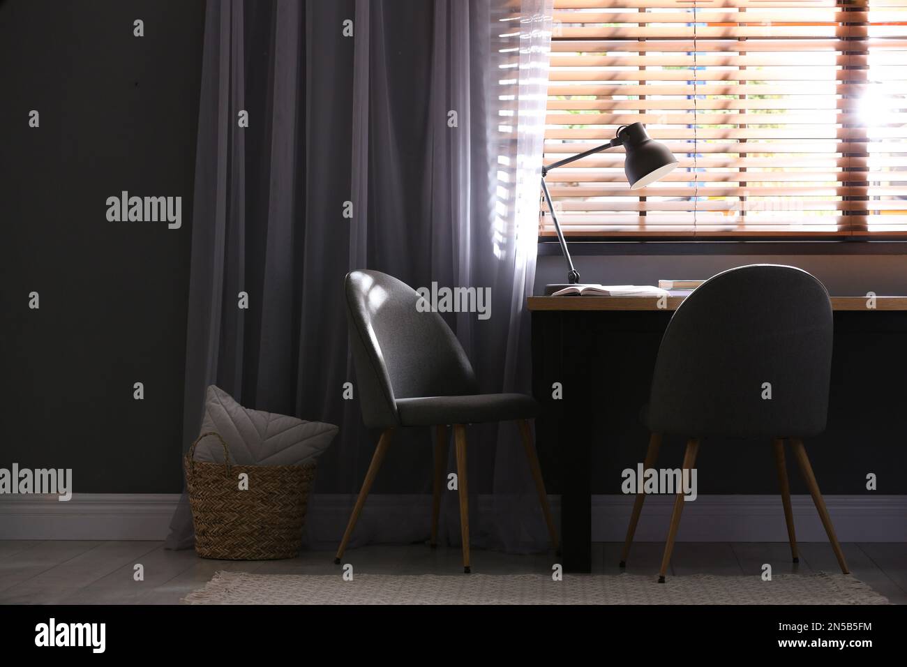 Comfortable chairs and desk near window with elegant curtains in room ...