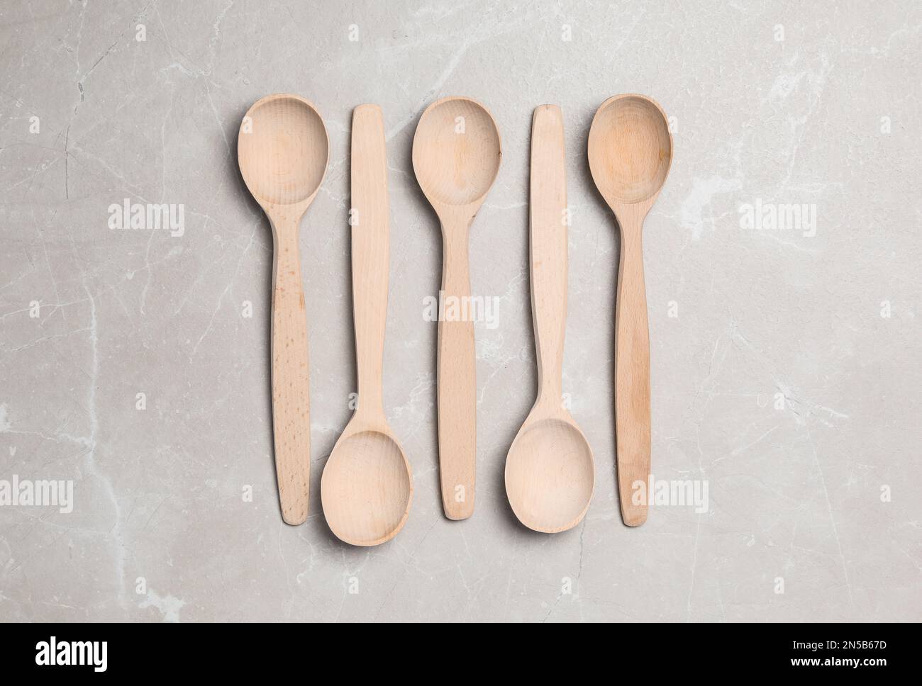 Wooden spoons on grey table, flat lay. Cooking utensils Stock Photo - Alamy