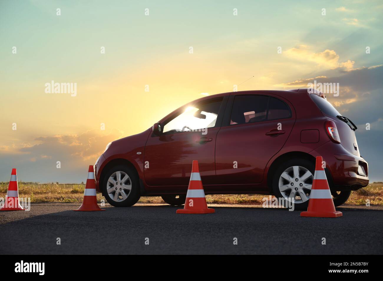 Traffic cones near red car outdoors. Driving school exam Stock Photo ...