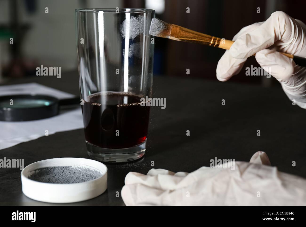Detective taking fingerprints with brush from glass, closeup Stock ...