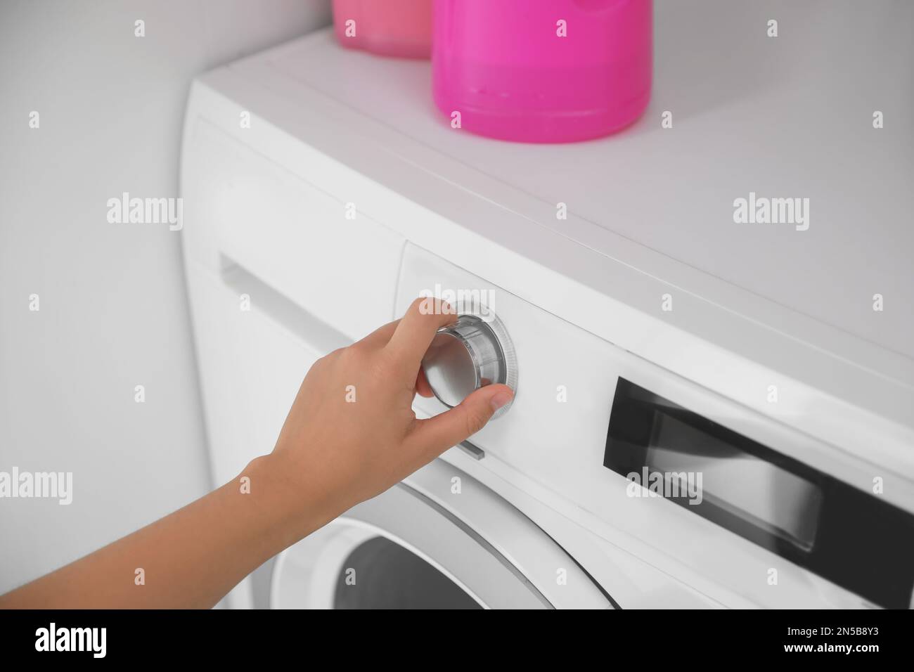Young woman turning washing hi-res stock photography and images - Alamy