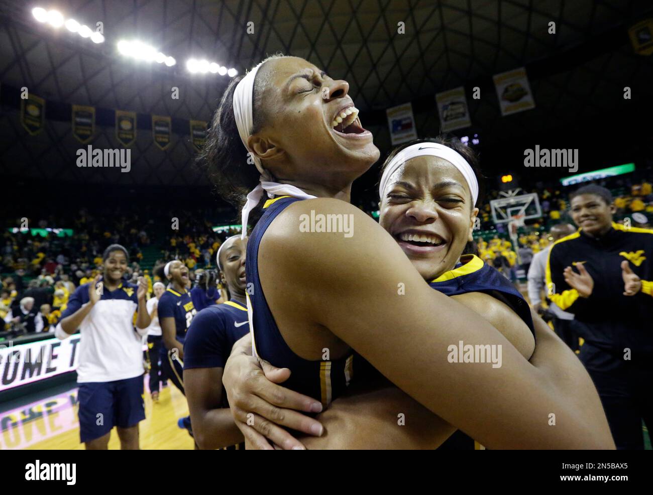 West Virginia center Asya Bussie, left, hugs teammate Christal Caldwell ...