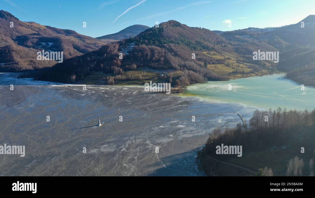 Aerial view of Geamana Village sunken in a frozen tailing lake. Clear ...