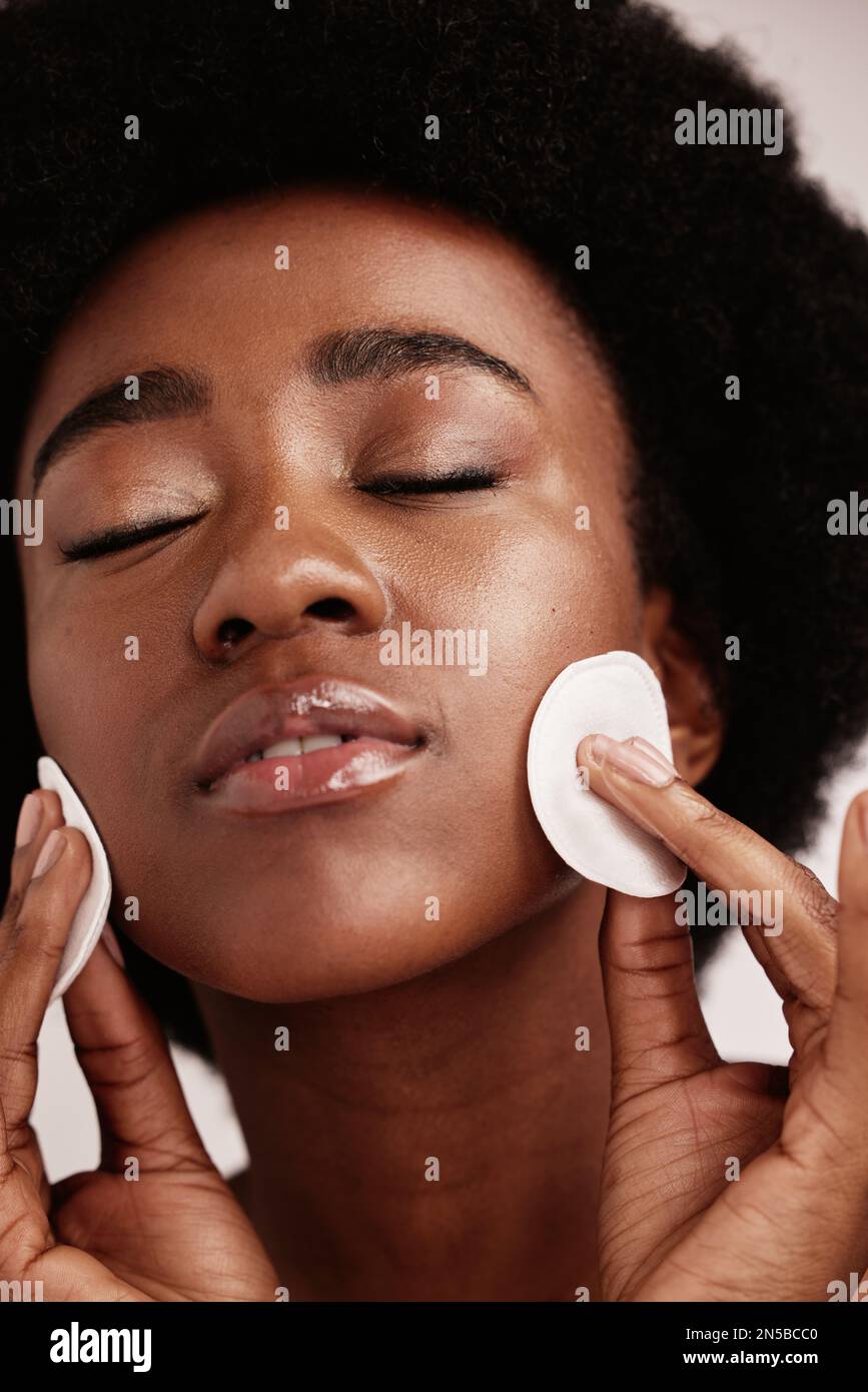Cleaning face, skin care and cotton for black woman in studio with ...