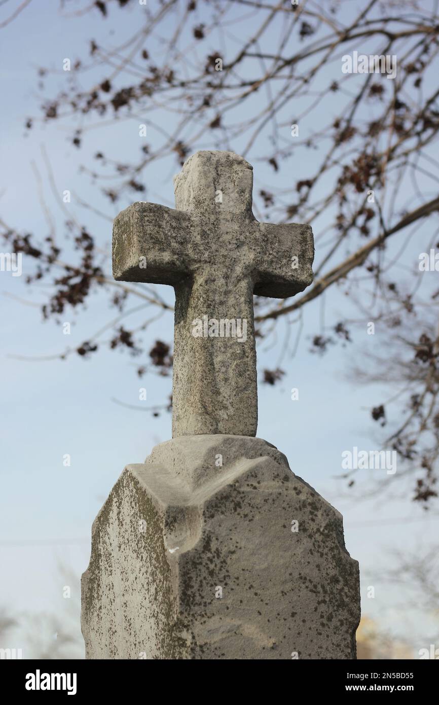 Simple vintage Christian cross standing high on a tombstone in the ...