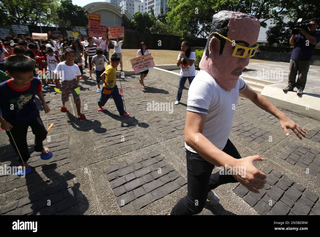 A Filipino man wearing a mask of Philippine President Benigno Aquino ...