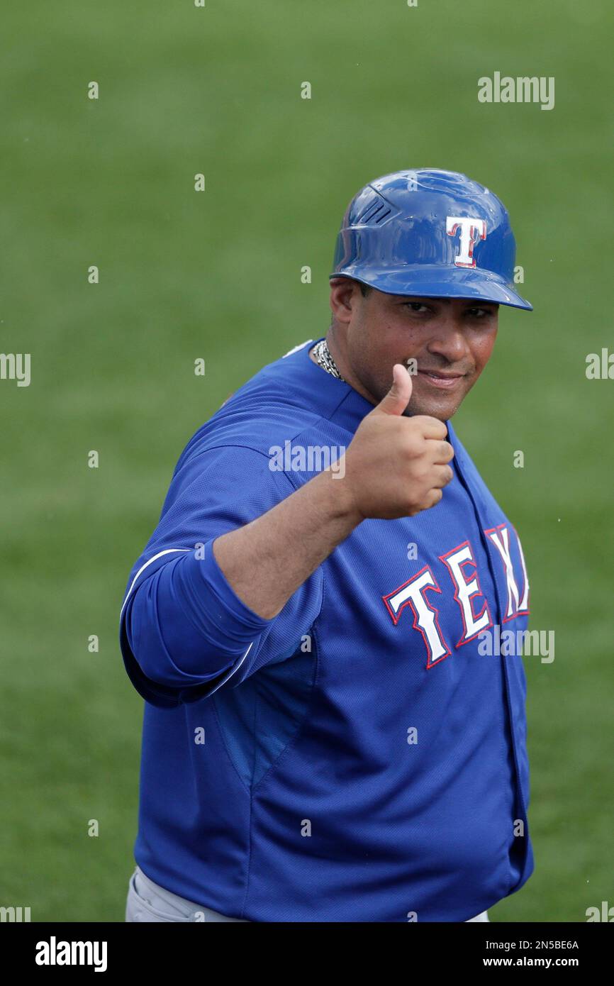 Texas Rangers first base coach Bengie Molina gestures to fans as the ...