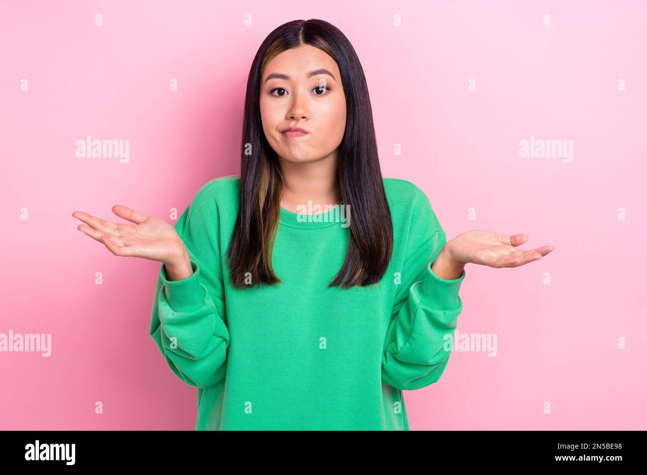Photo of doubtful unsure girl dressed green sweatshirt shrugging ...