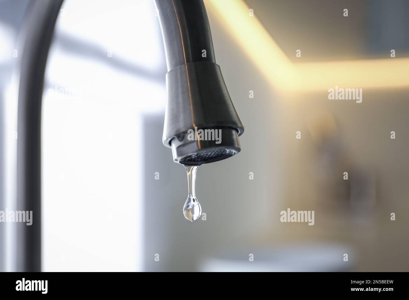 Water drop falling down from tap on blurred background, closeup Stock ...