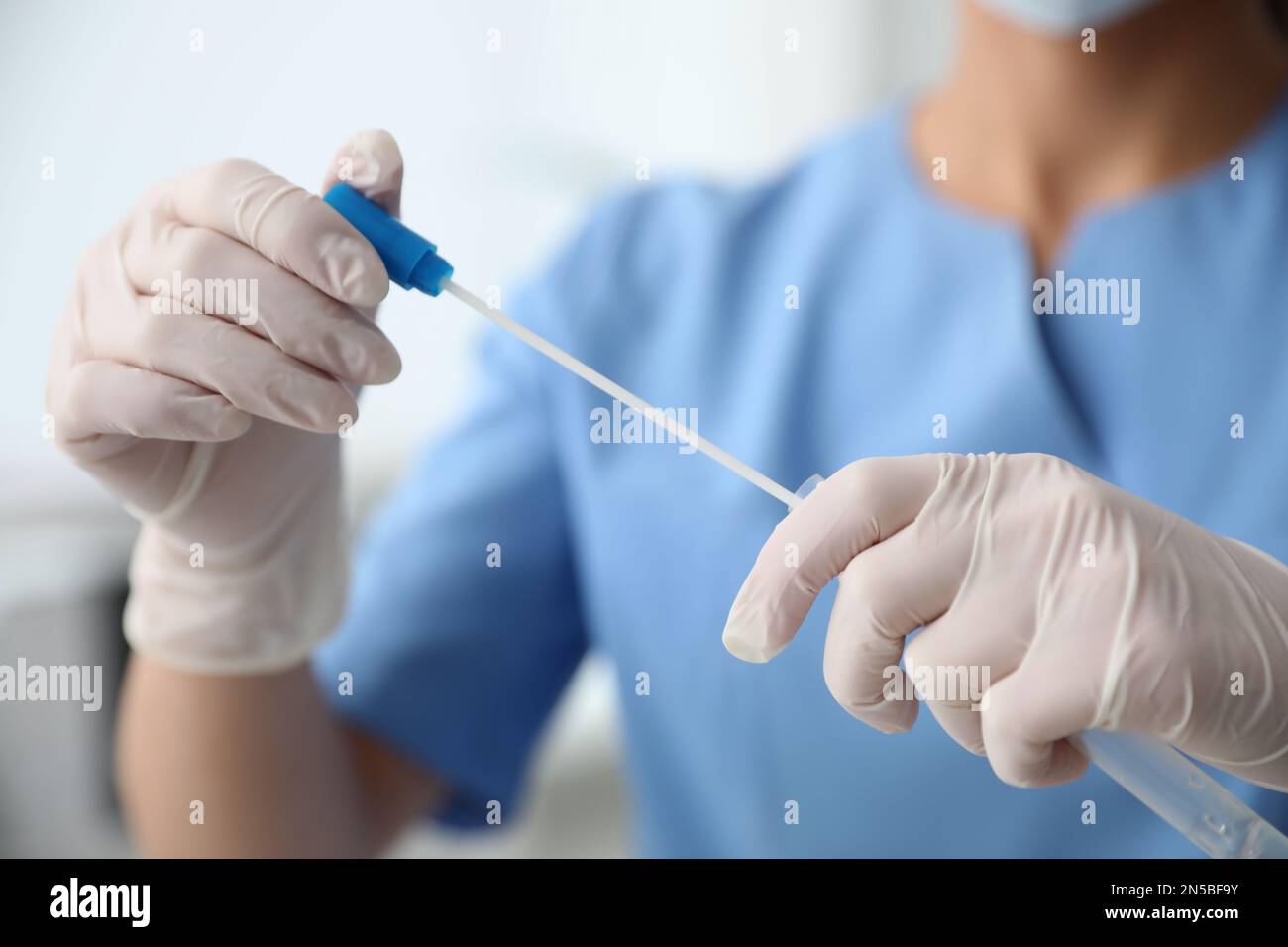 Doctor holding buccal cotton swab and tube for DNA test in clinic ...