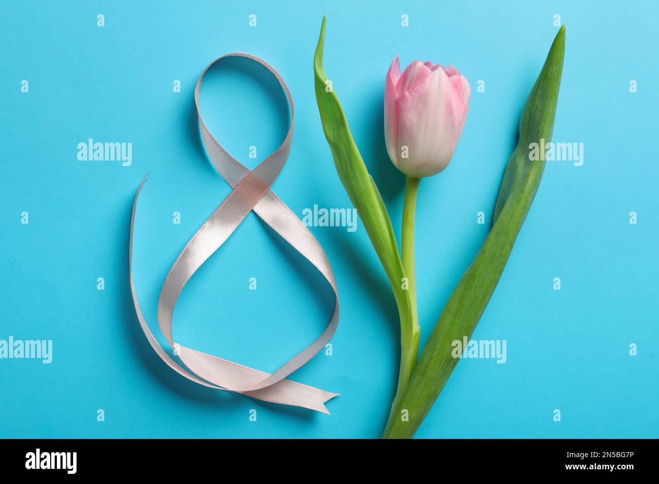 8 March card design with tulip on light blue background, flat lay ...