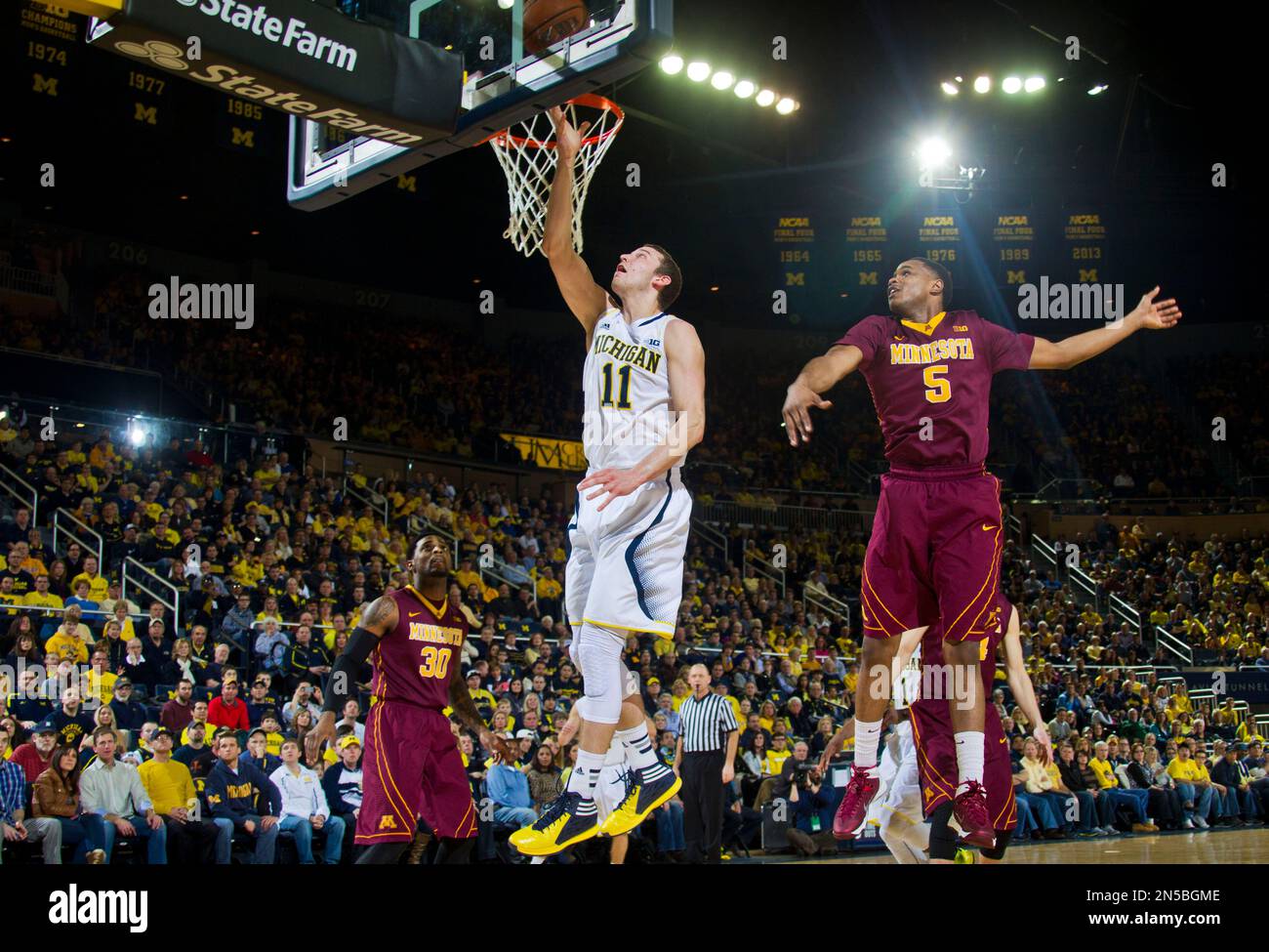Michigan guard Nik Stauskas (11) makes a layup while defended by ...