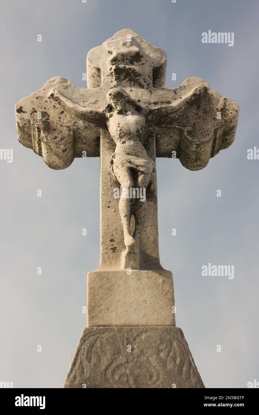 Simple vintage Christian cross standing high on a tombstone in the ...
