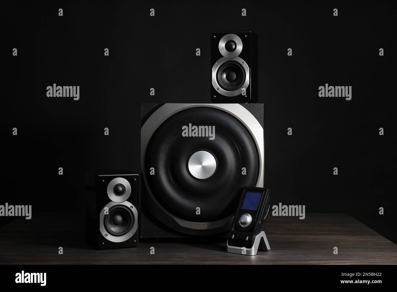Modern powerful audio speaker system with remote on wooden table ...