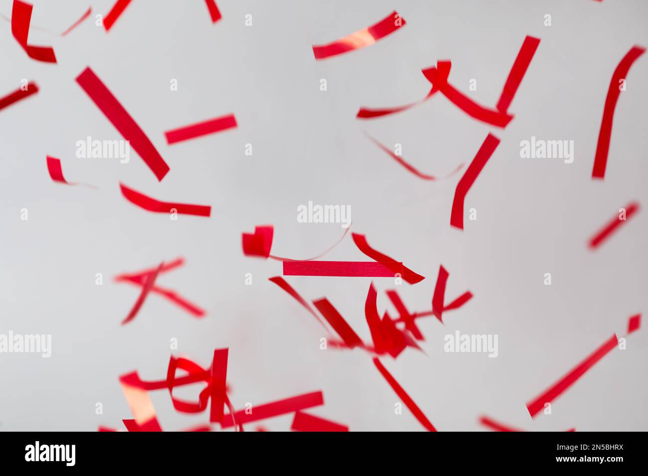 Shiny red confetti falling down on light grey background Stock Photo ...