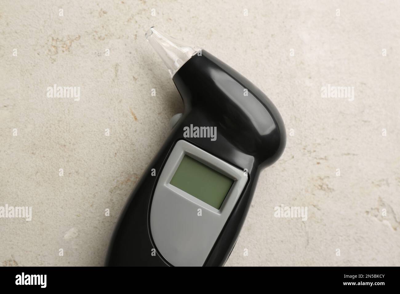Modern breathalyzer with blank screen on light grey stone table, top ...