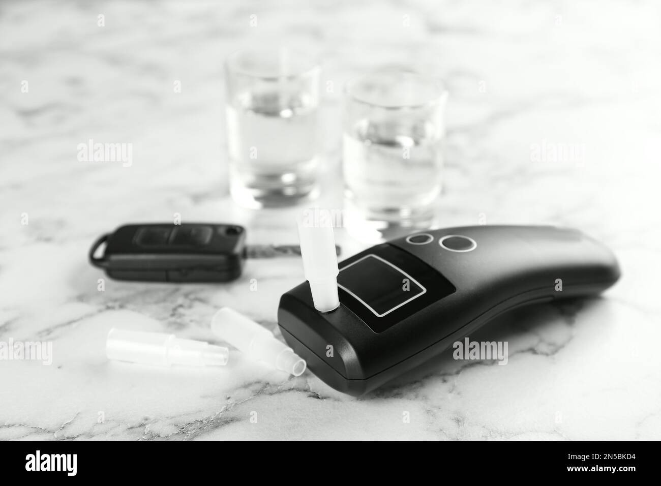 Modern breathalyzer and mouthpieces on white marble table Stock Photo ...
