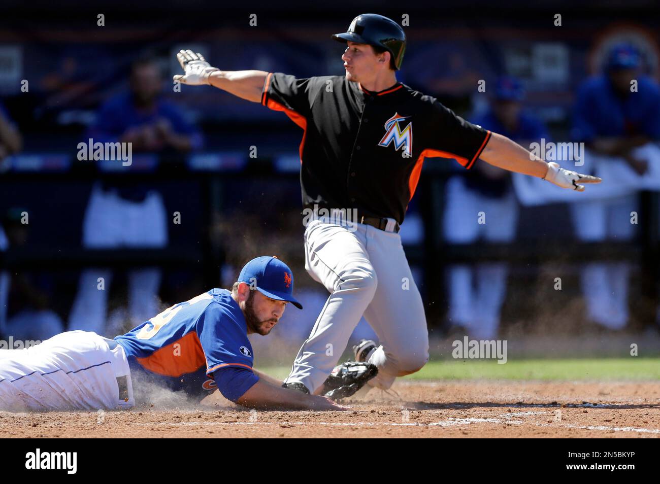 Miami Marlins' Rob Brantly, right, scores on a wild pitch by New York ...