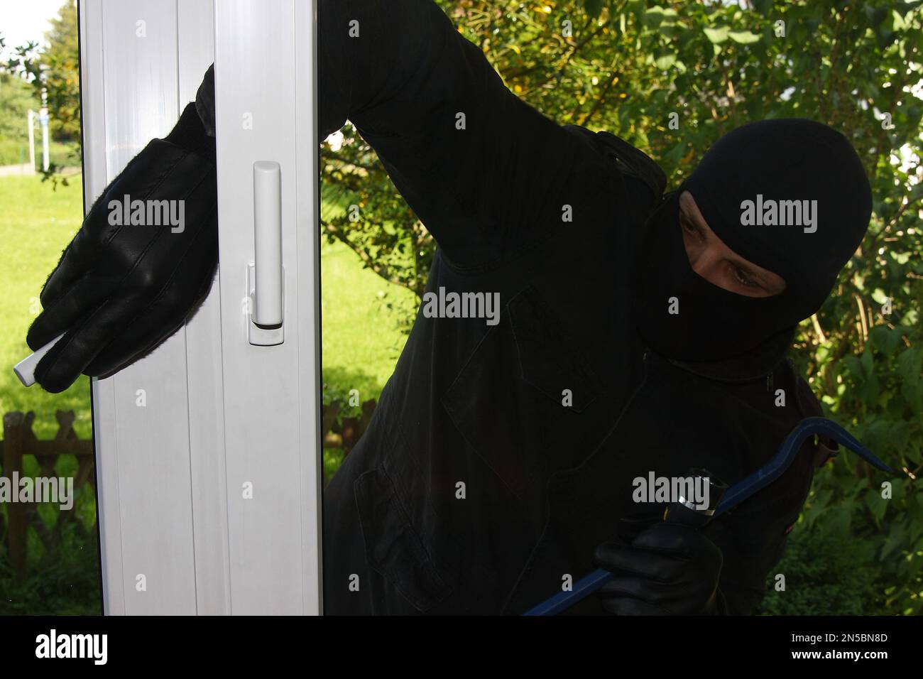 masked burglar with crowbar on a tilted window Stock Photo - Alamy