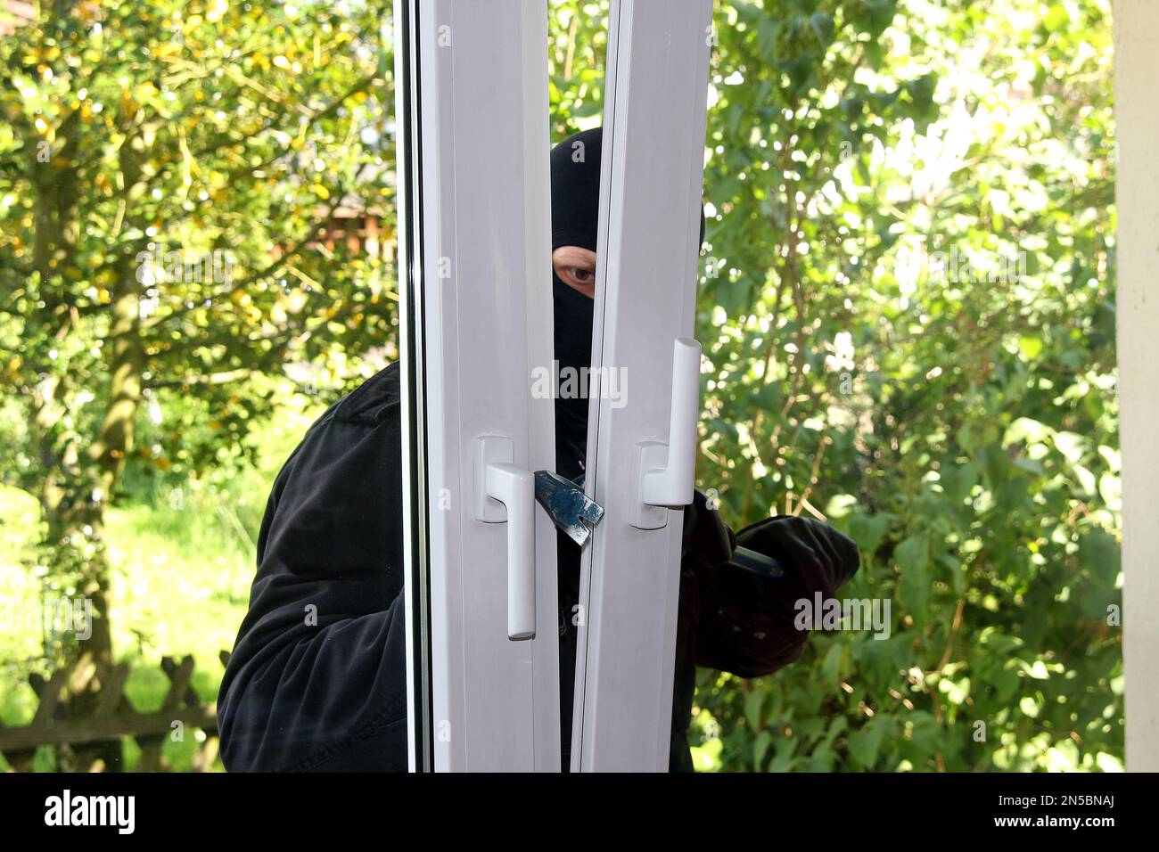 masked burglar with crowbar on a tilted window Stock Photo - Alamy