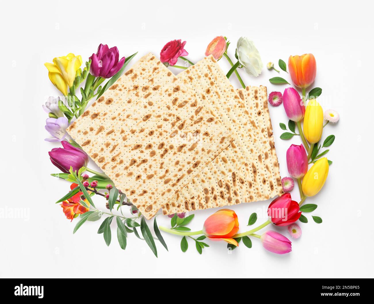 Tasty matzos and flowers on white background, top view. Passover ...
