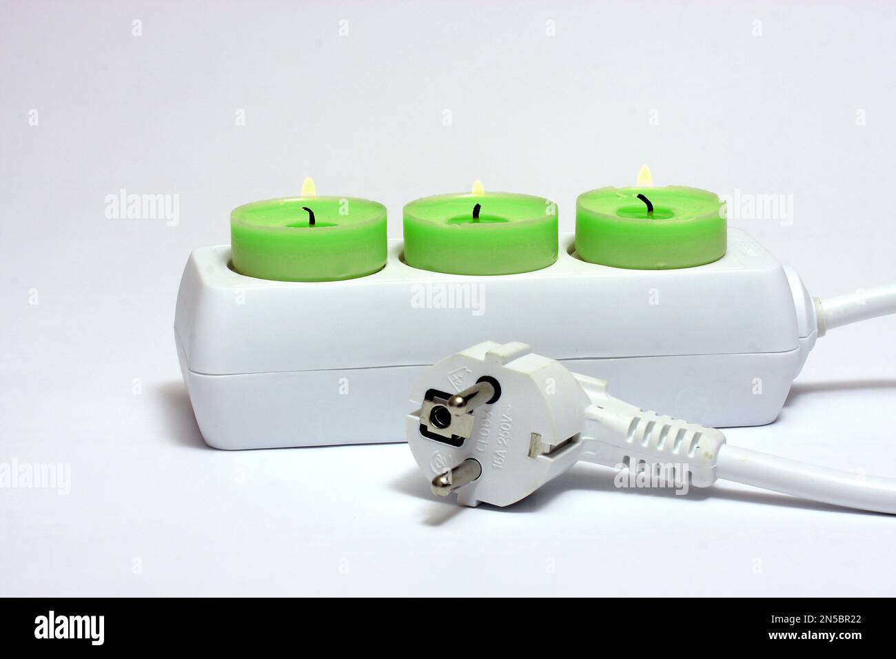 power socket with green tea candles, saving energy Stock Photo - Alamy
