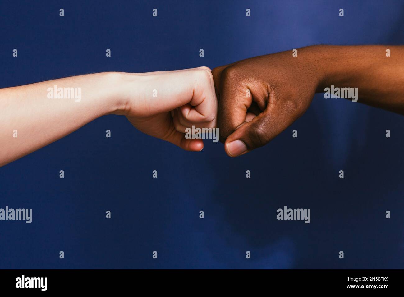 Black and white hand, fist bump gesture, contrast Stock Photo - Alamy