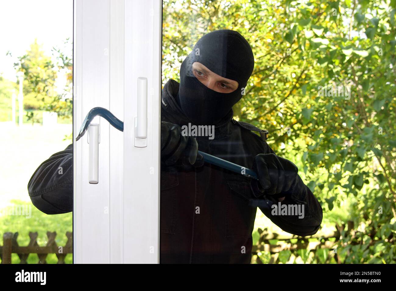 masked burglar with crowbar on a tilted window Stock Photo - Alamy