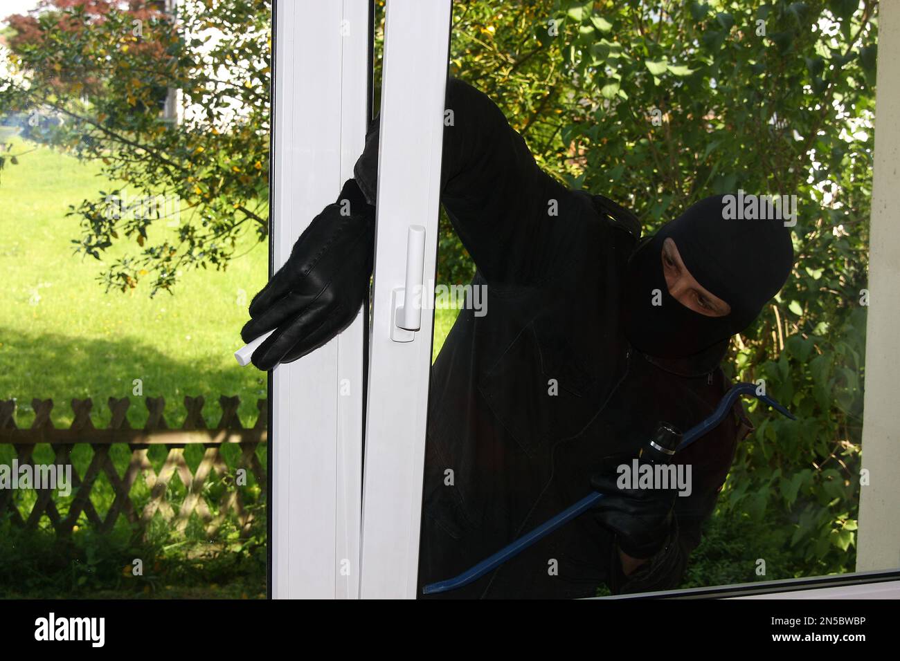 masked burglar with crowbar on a tilted window Stock Photo - Alamy
