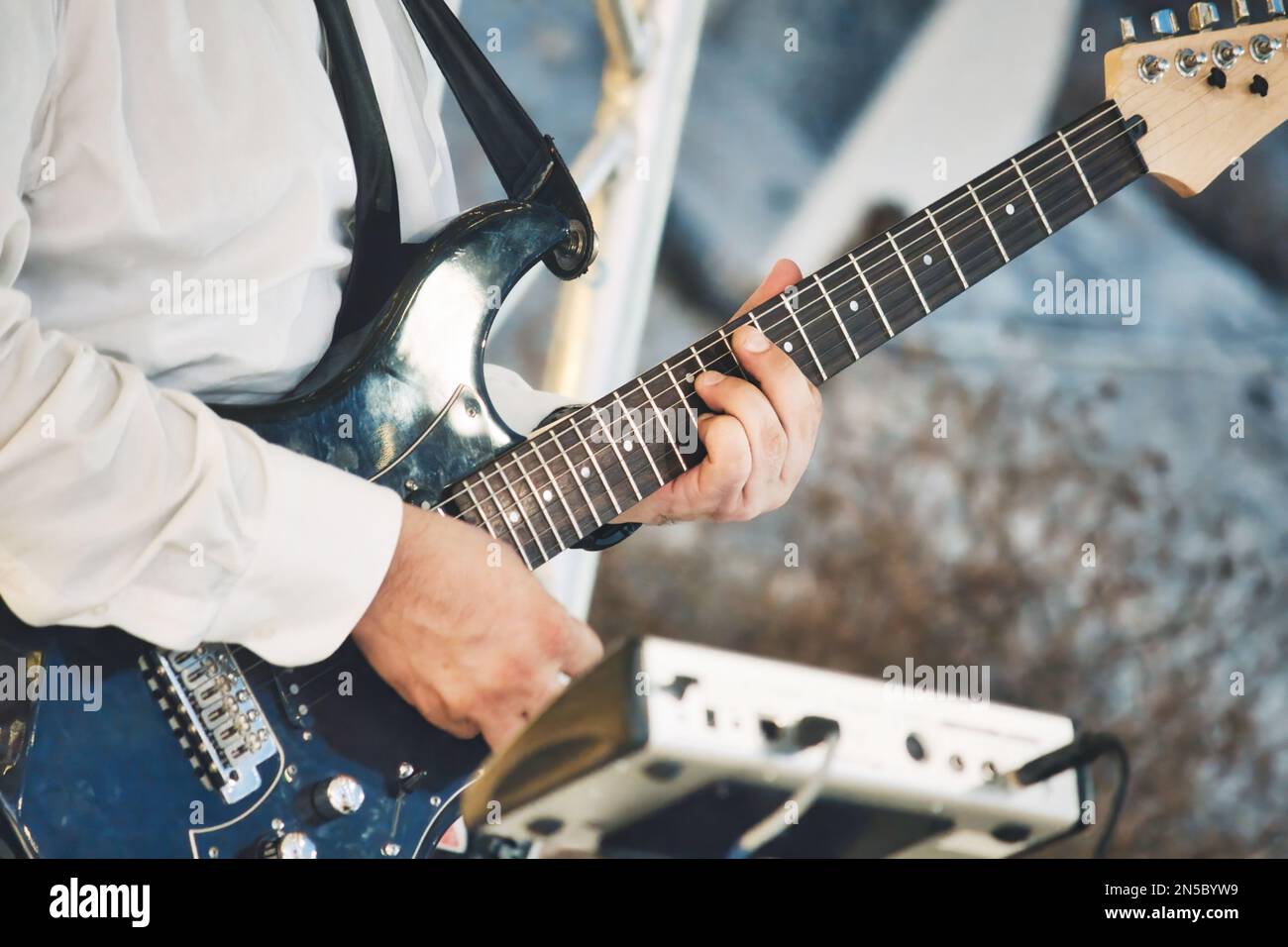 Close-up of a professional man's hands playing the fretboard of an ...