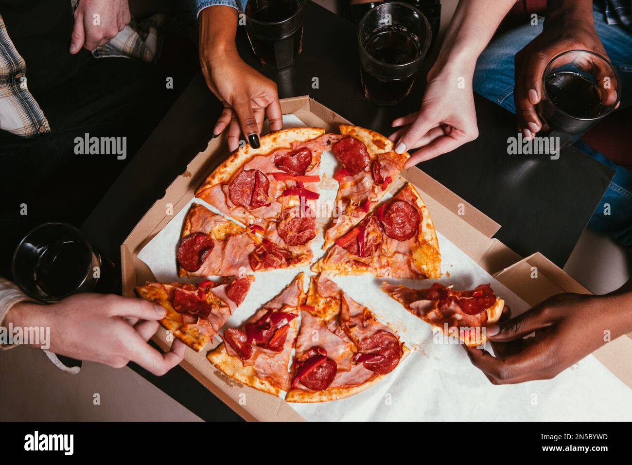 Four friends company eat fresh pizza at home Stock Photo - Alamy