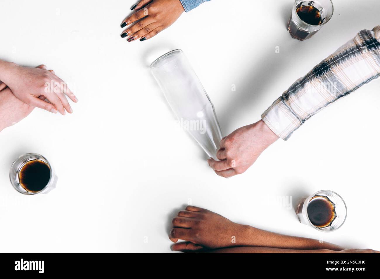Four friends play spin the bottle game, flat lay Stock Photo - Alamy