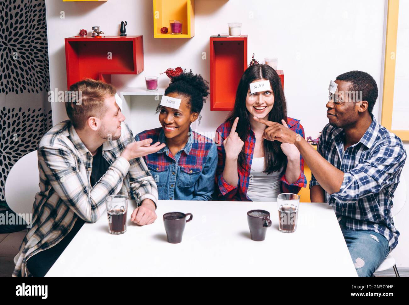 Playing game guess who am I, four friends have fun Stock Photo - Alamy