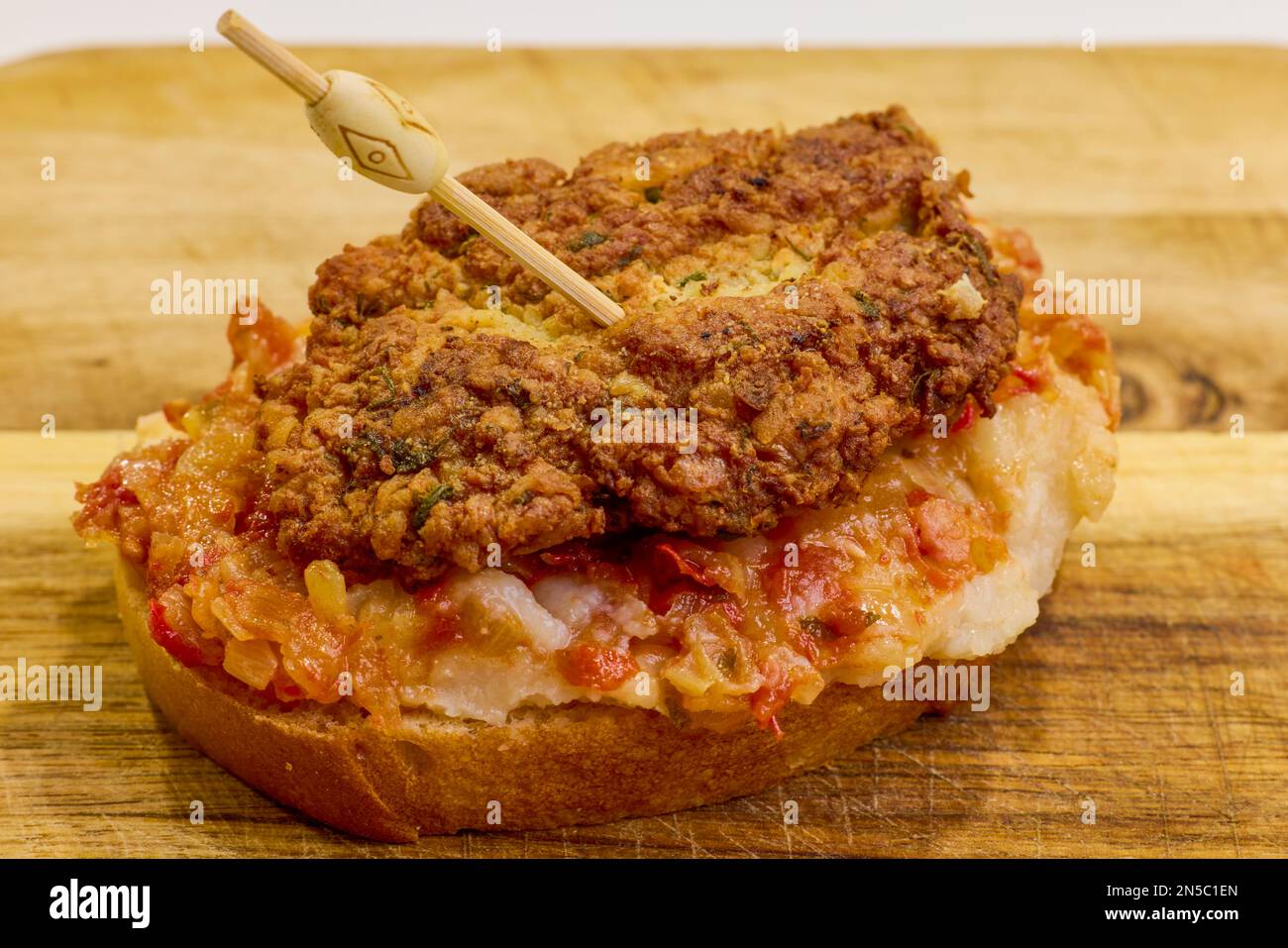 meat dish on a slice of bread with beans Stock Photo - Alamy