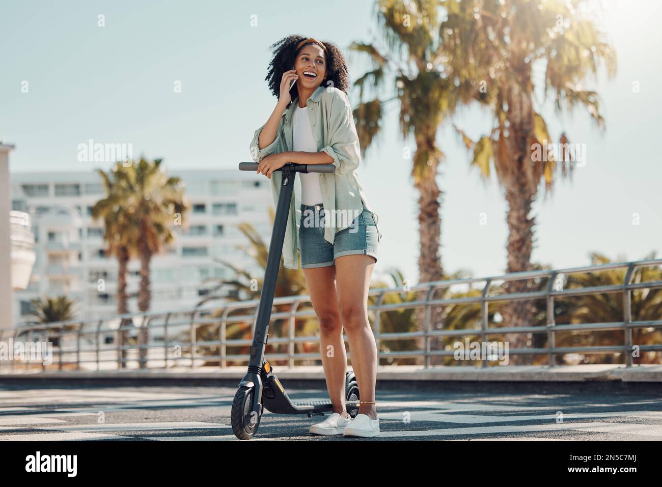 Scooter, phone call and black woman in city talking, chatting or ...