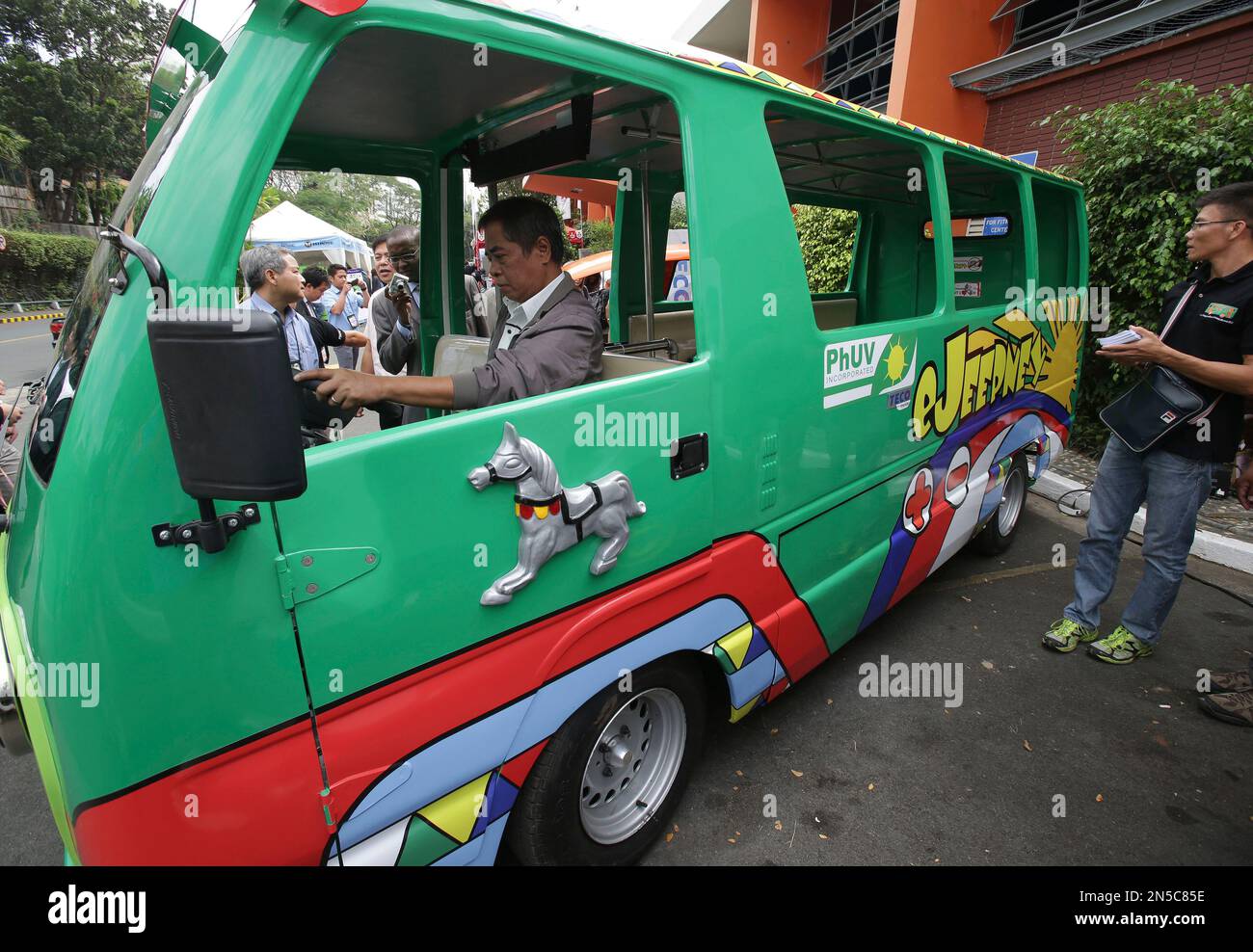 A Filipino delegate checks out an electric powered passenger jeepney ...