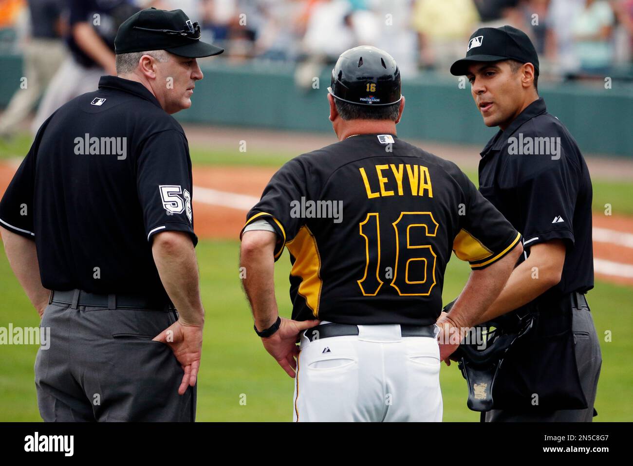 Umpires Gabe Morales, right, and Anthony Johnson, left, talk with ...