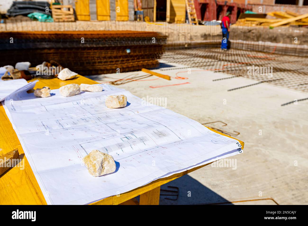 Architectural blueprints, drawings spread out on the improvised table ...