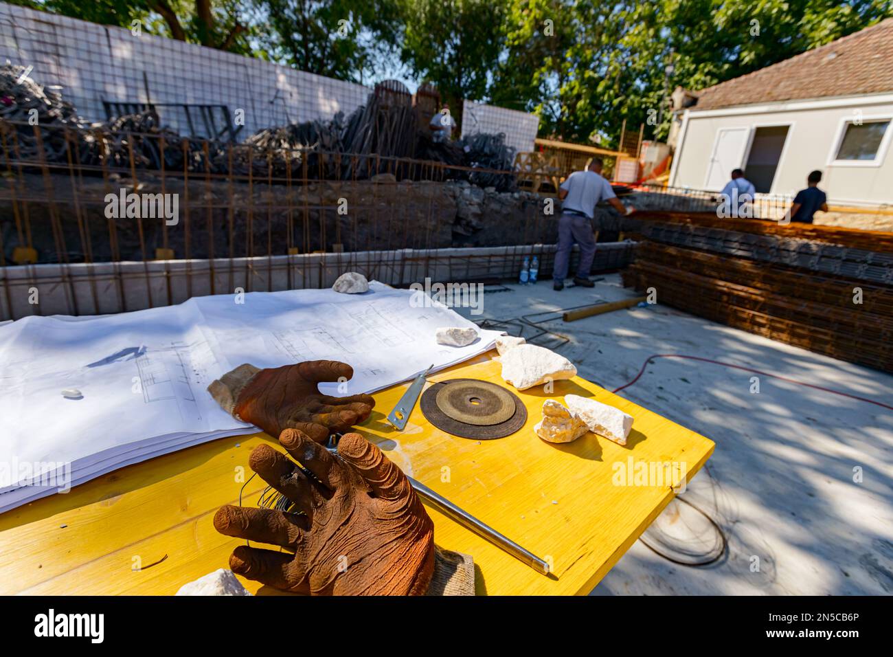 Architectural blueprints, drawings spread out on the improvised table ...