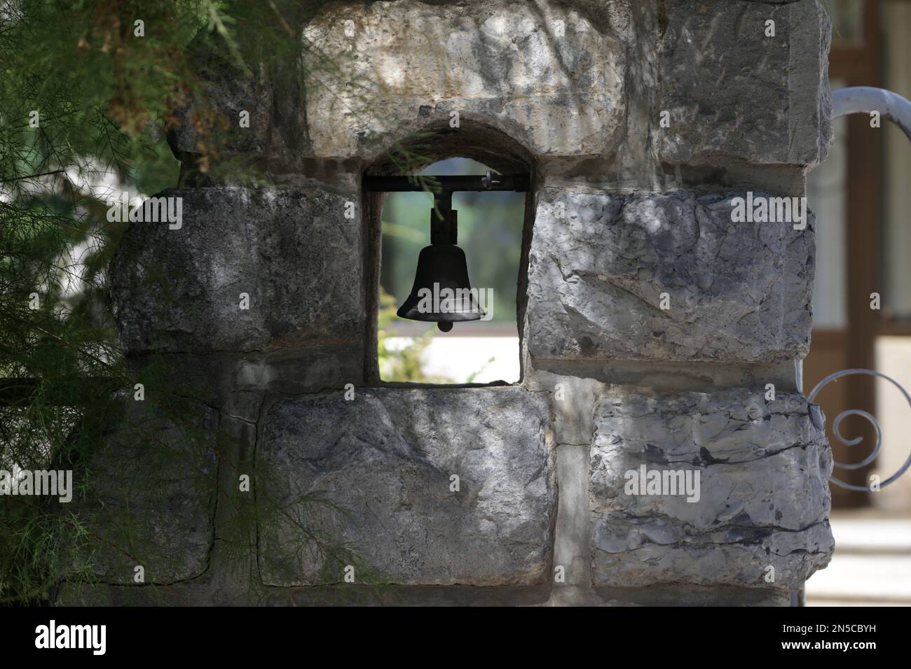 A close-up shot of a small bell that is affixed to a traditional, aged ...