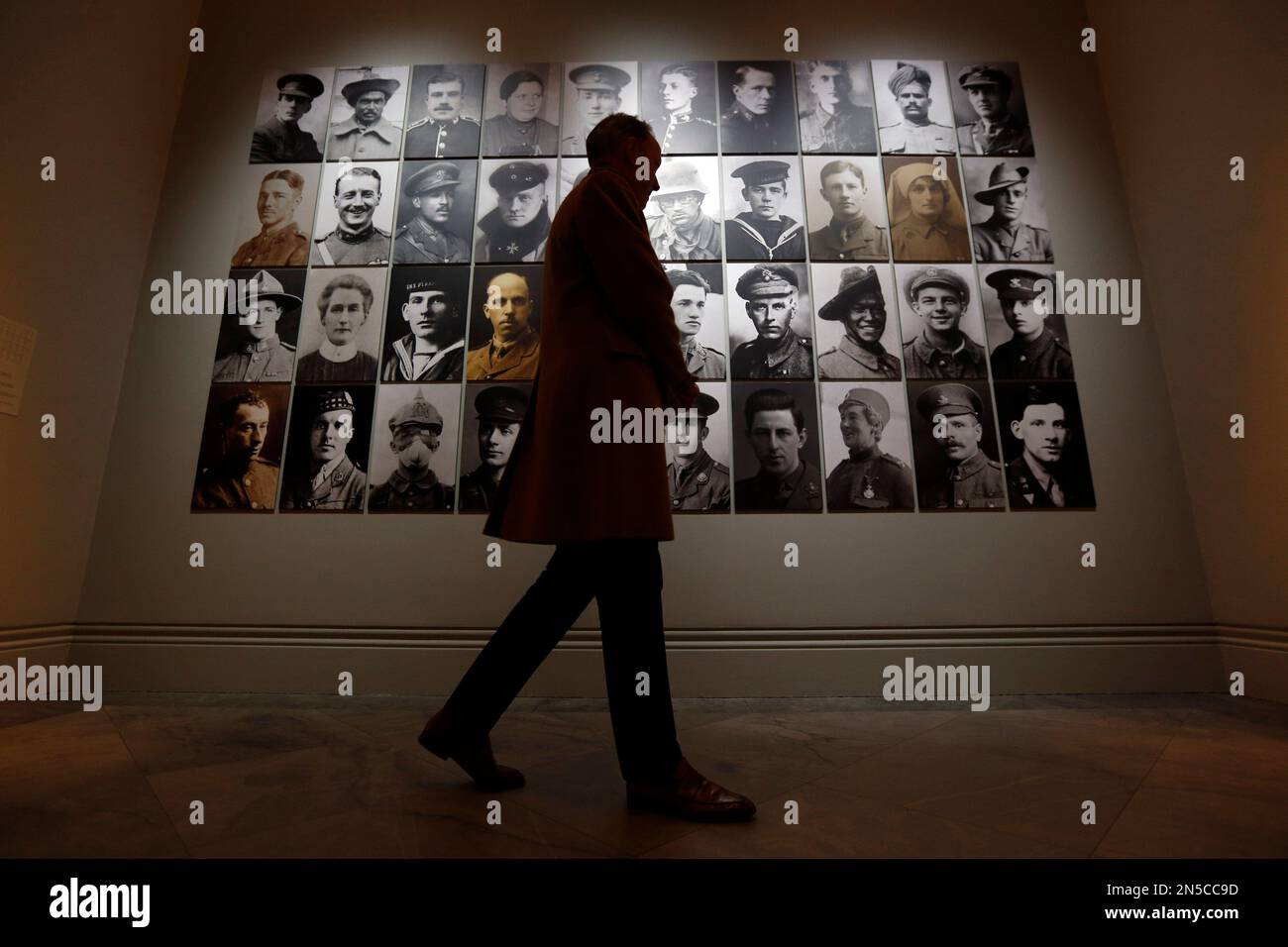 A visitor walks past a collage of photographs of World War One-era ...