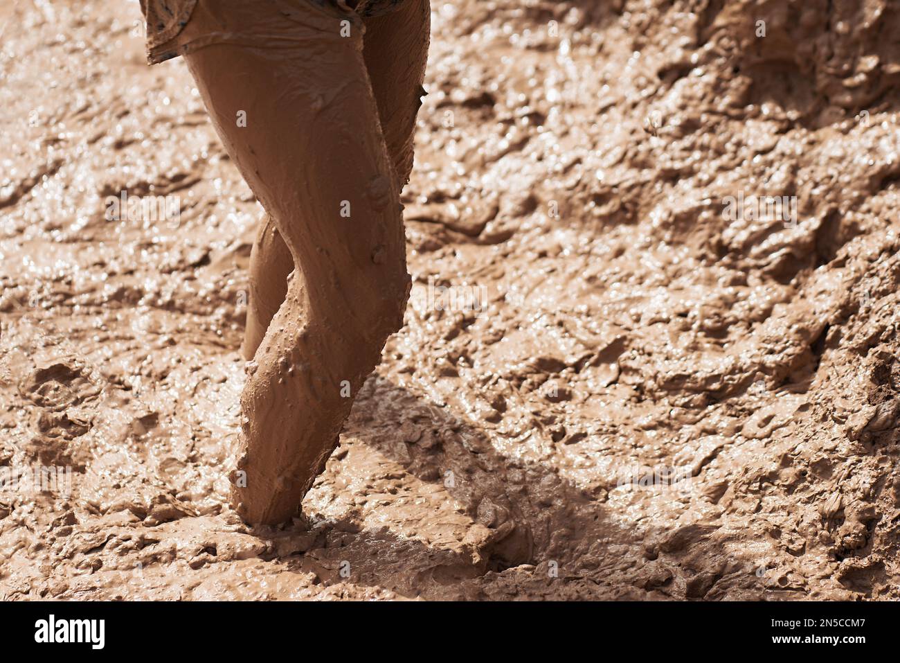 Mud race runner participant wades through, muddy feet Stock Photo - Alamy