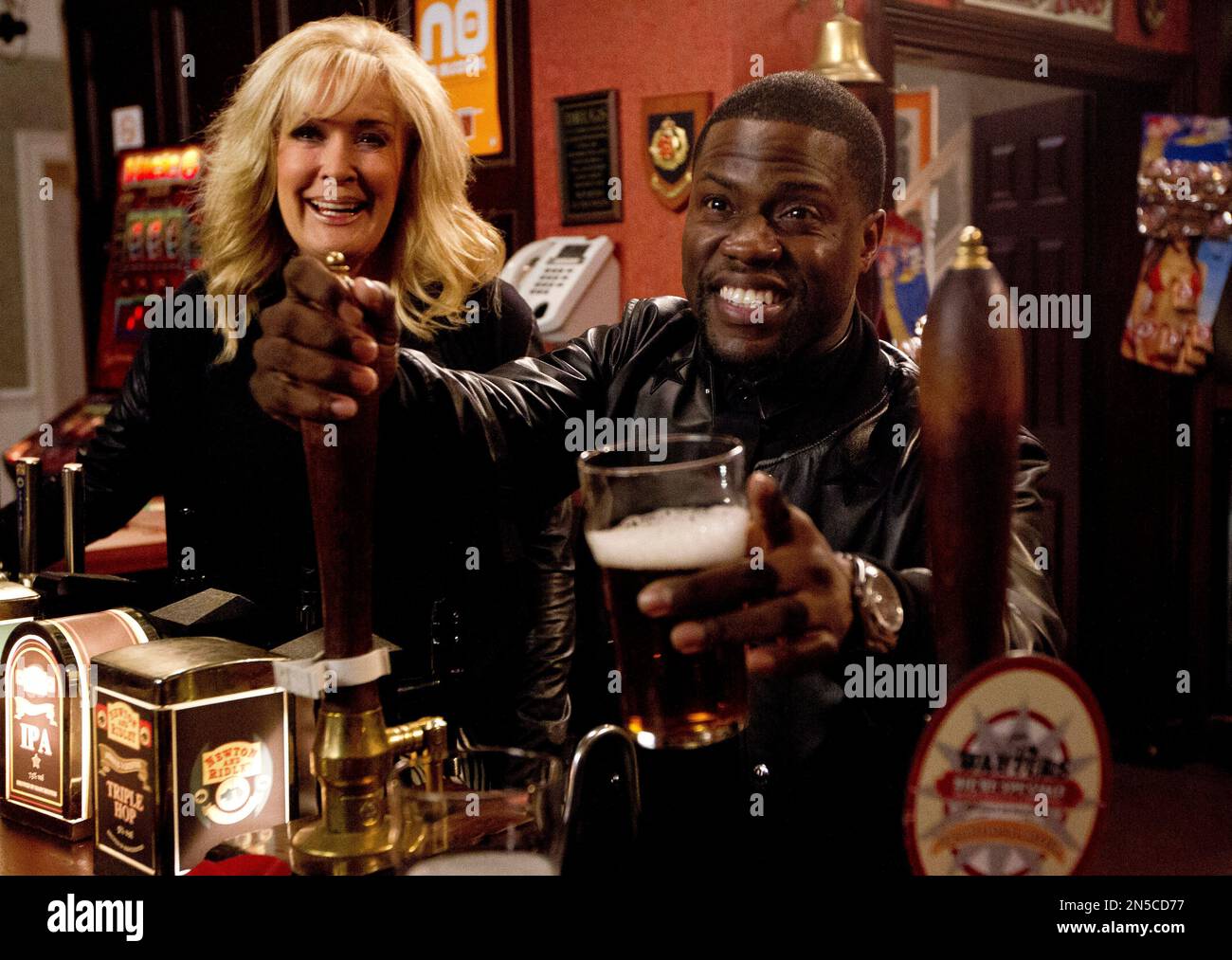 Ride Along actor and comedian Kevin Hart, right, is shown how to pour a ...